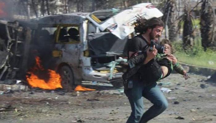 Syrian photographer leaves camera aside to carry injured kid in arms ...